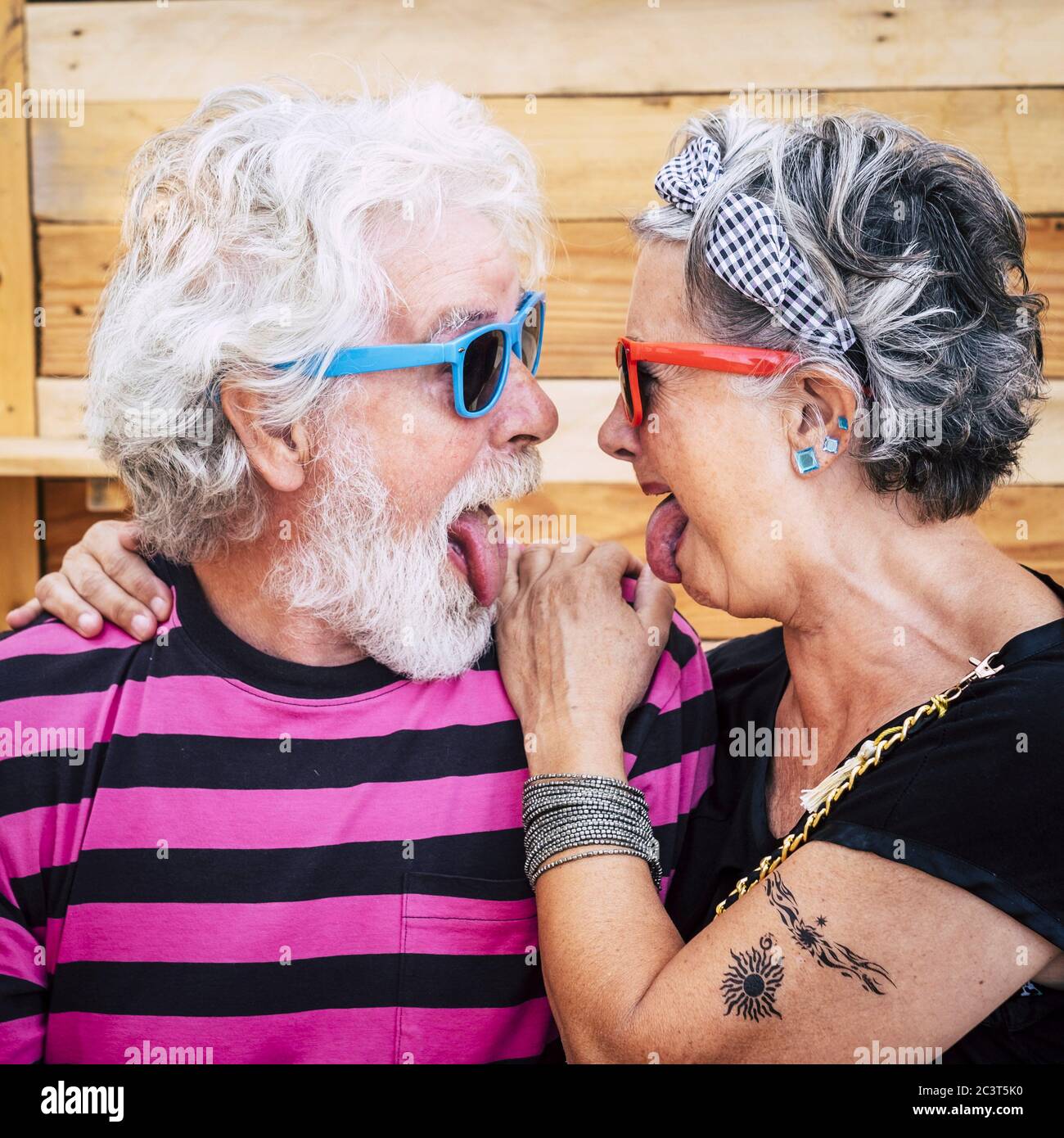 Portrait of cheerful caucasian senior crazy couple with wood background ...