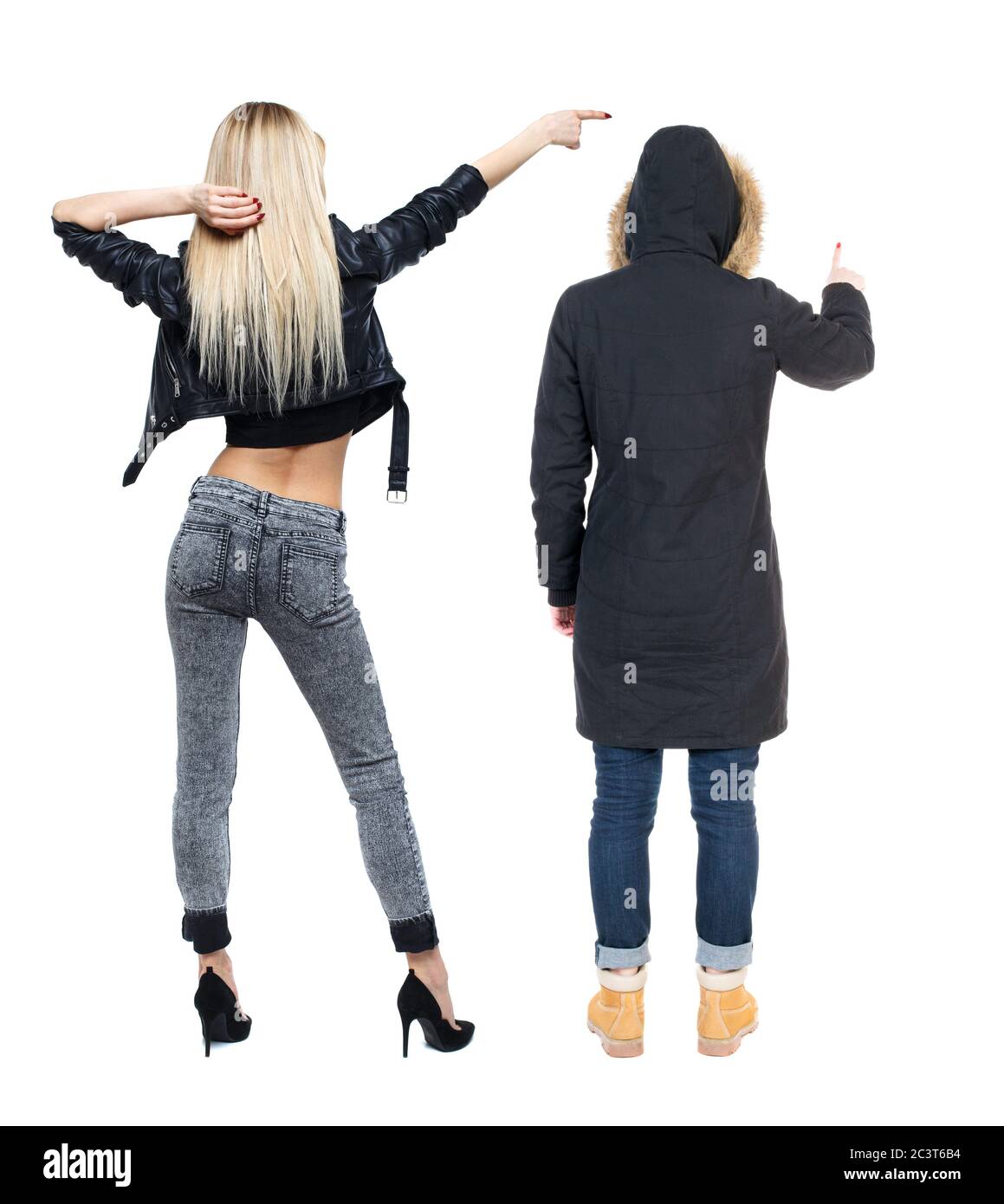 Back view of two pointing young girl in winter jacket. Rear view people ...
