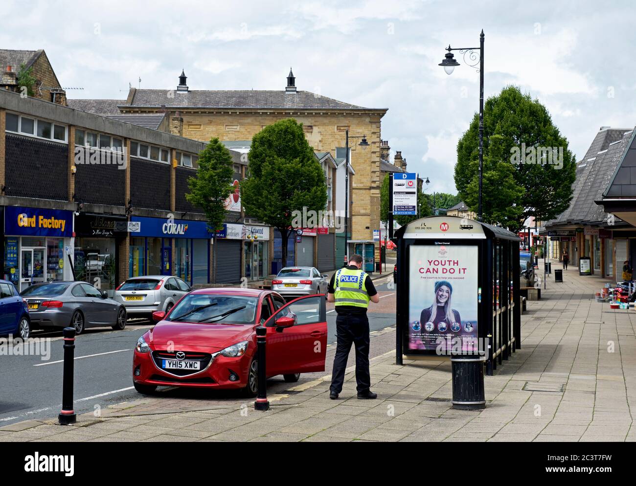 Policeman checking car parked at bus stop, Batley, West Yorkshire ...