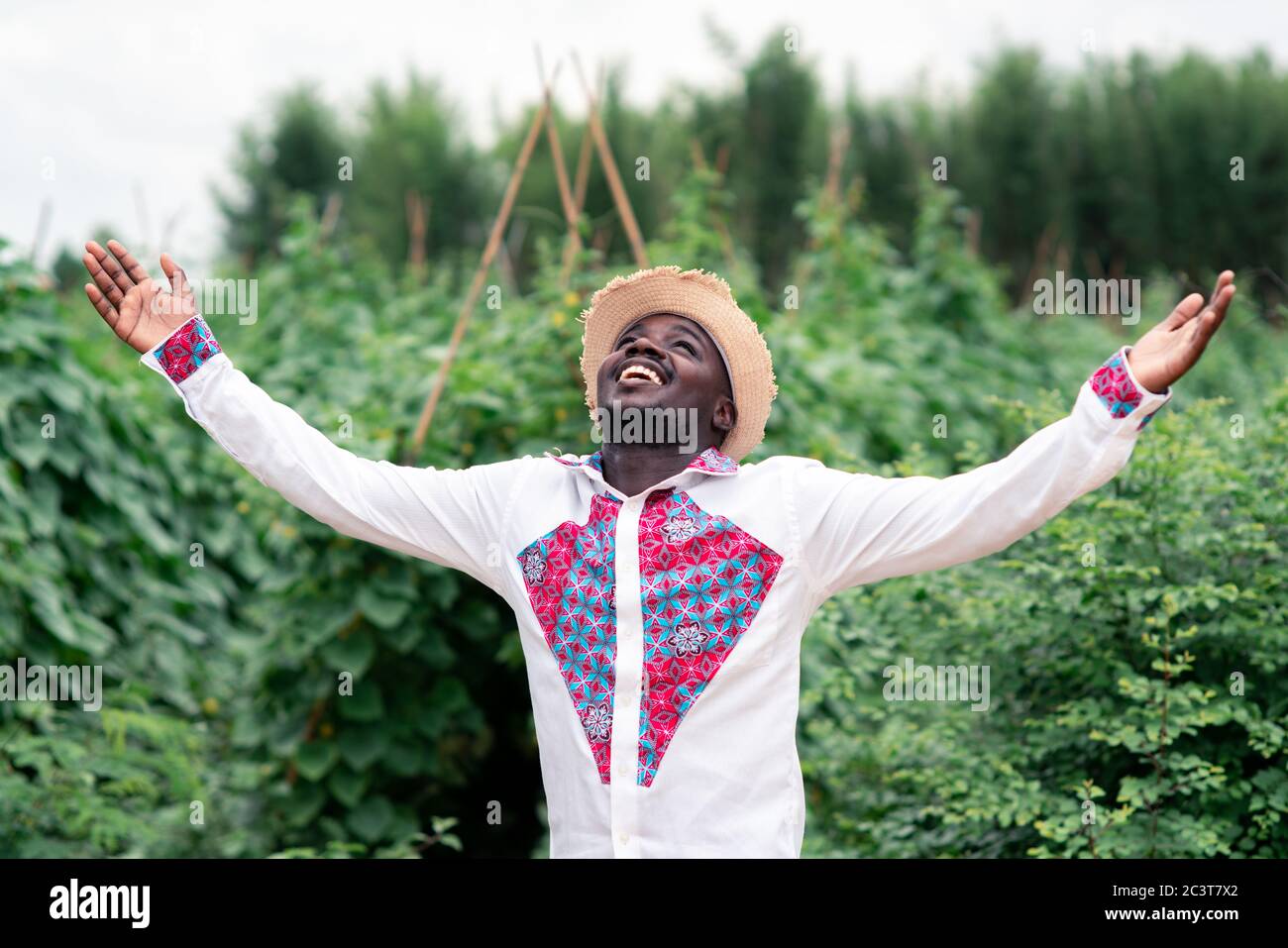 African farmer man standing in the organic farm with wearing native ...