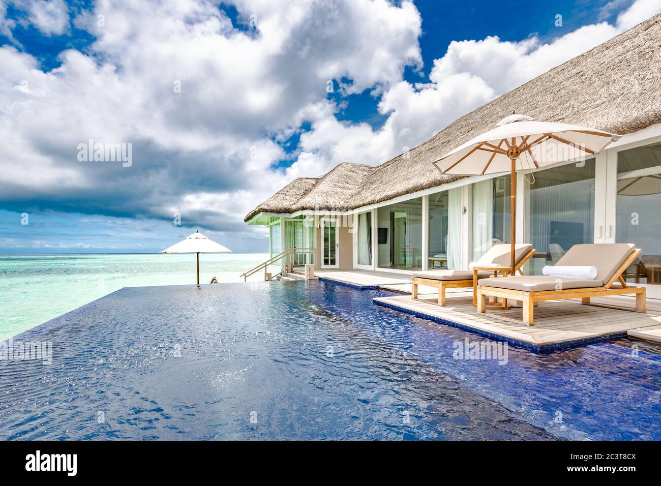 Luxury beach resort with infinity pool, loungers or beach chairs under ...