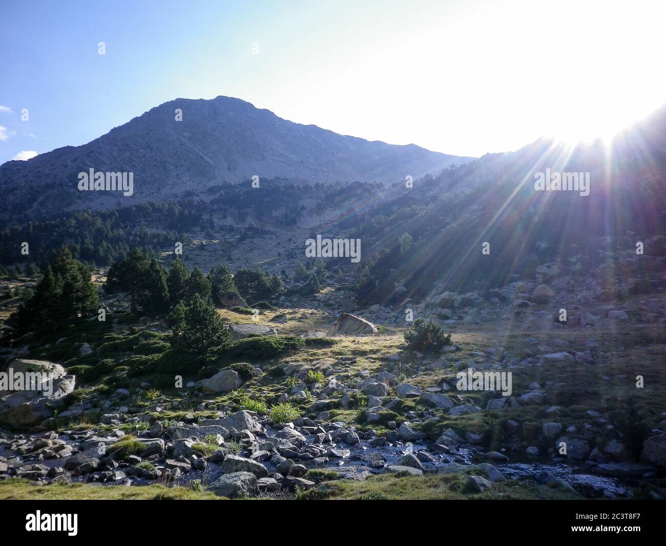 Sunrise of a high mountain valley with a small river surrounded by ...