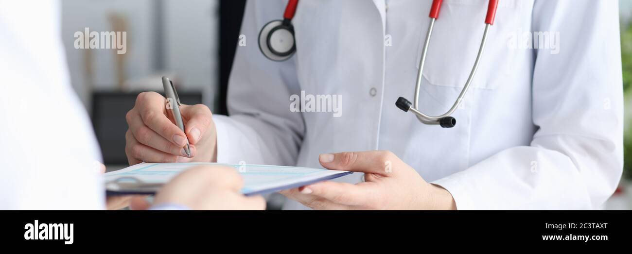 Female doctor signs patient card with diagnosis Stock Photo - Alamy