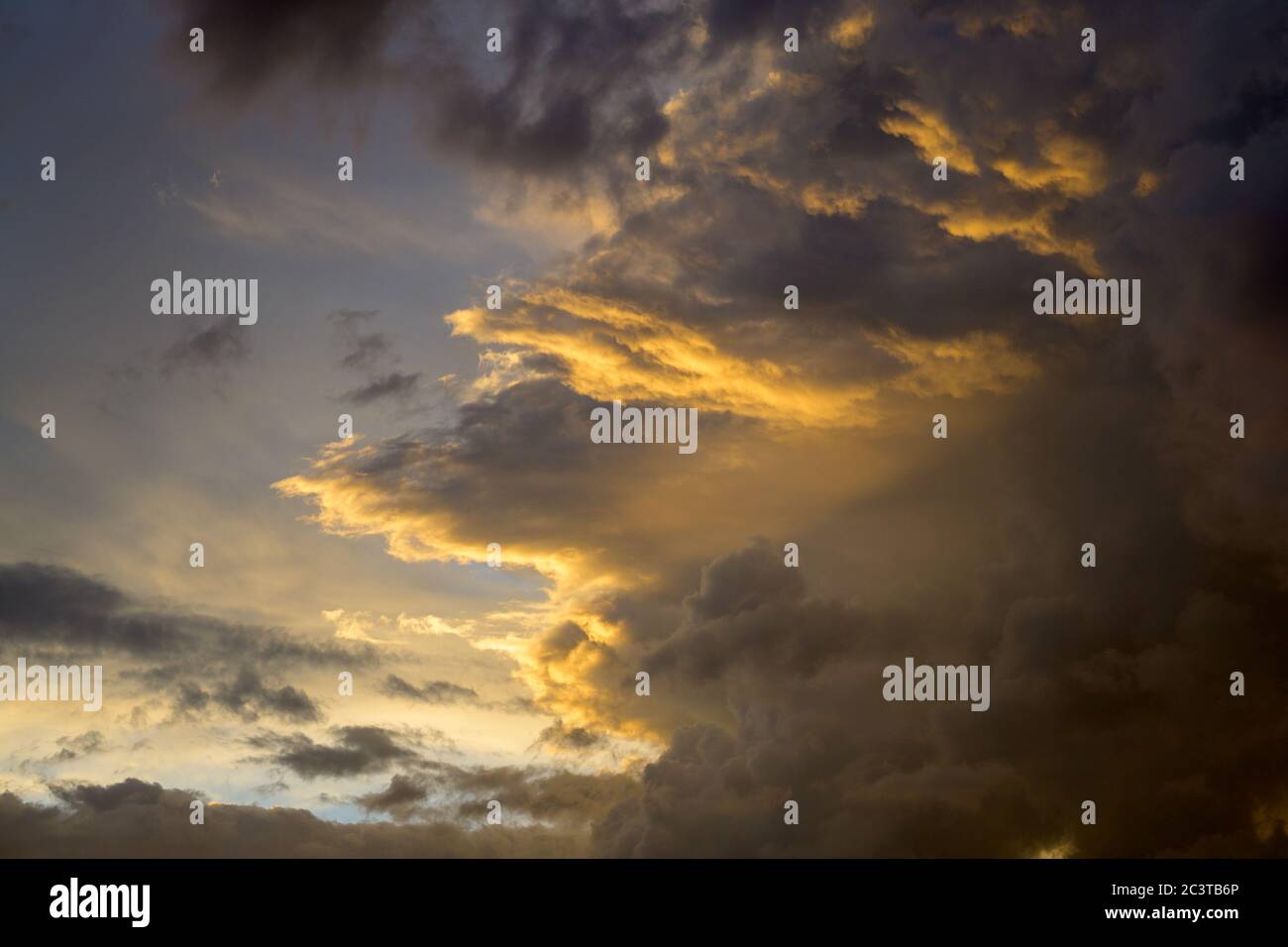 Colorful orange sunset with grey storm clouds gathering ahead of a ...