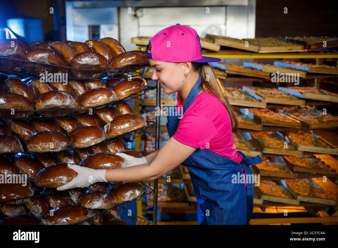 A female baker is at the workplace at the bakery. A professional baker ...