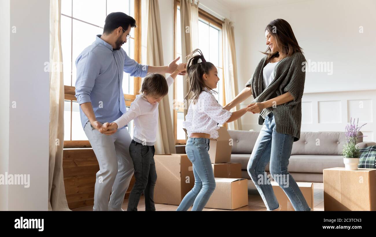 Excited parents with children celebrating moving day in new house Stock ...