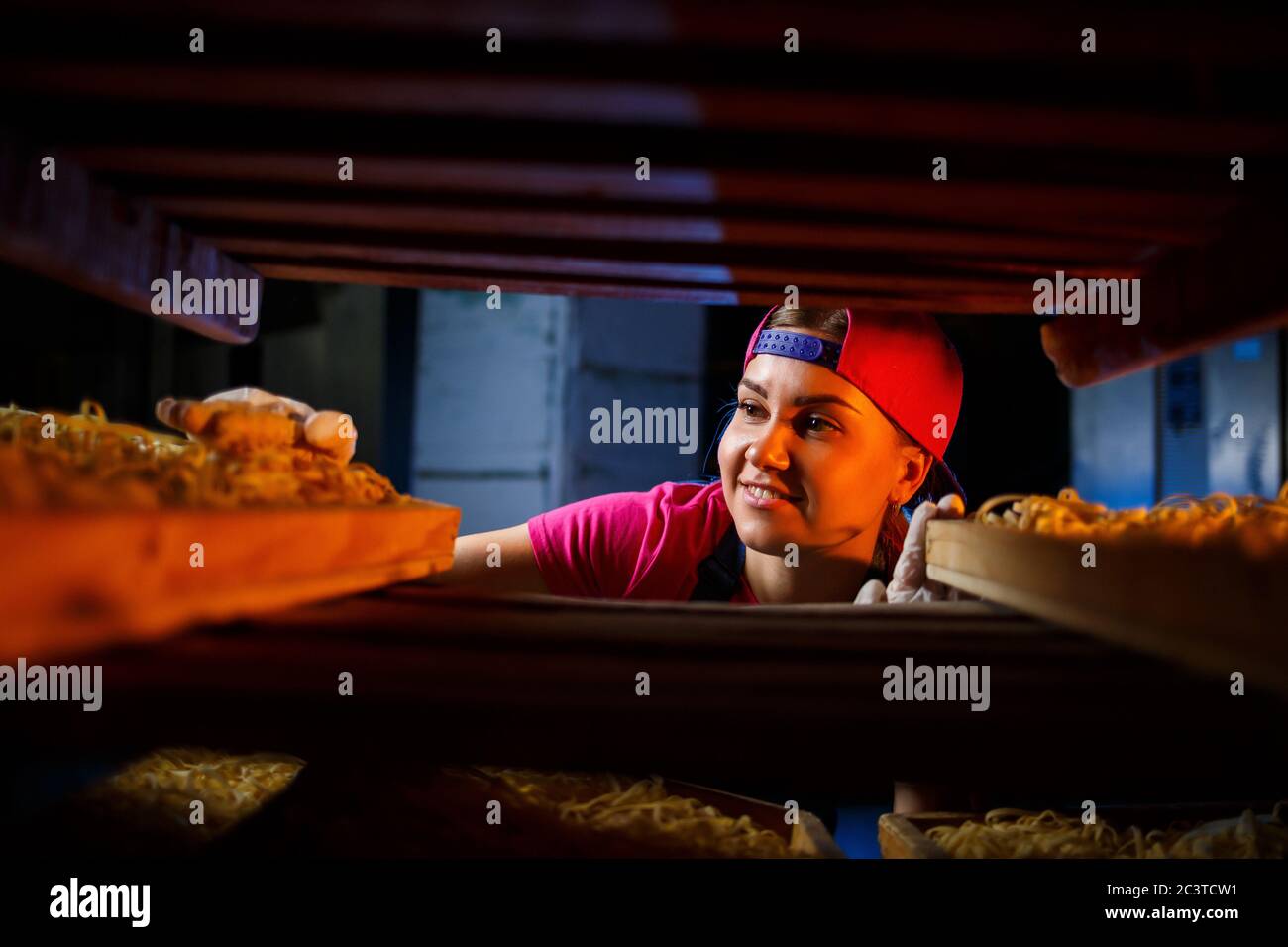 The girl works on the production of spaghetti. Making noodles. Pasta ...