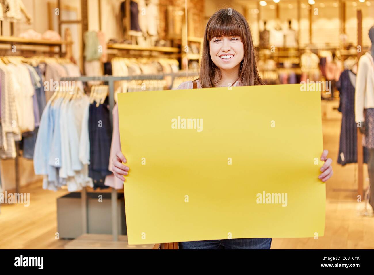 Woman holds yellow blank retail sign from mall Stock Photo - Alamy