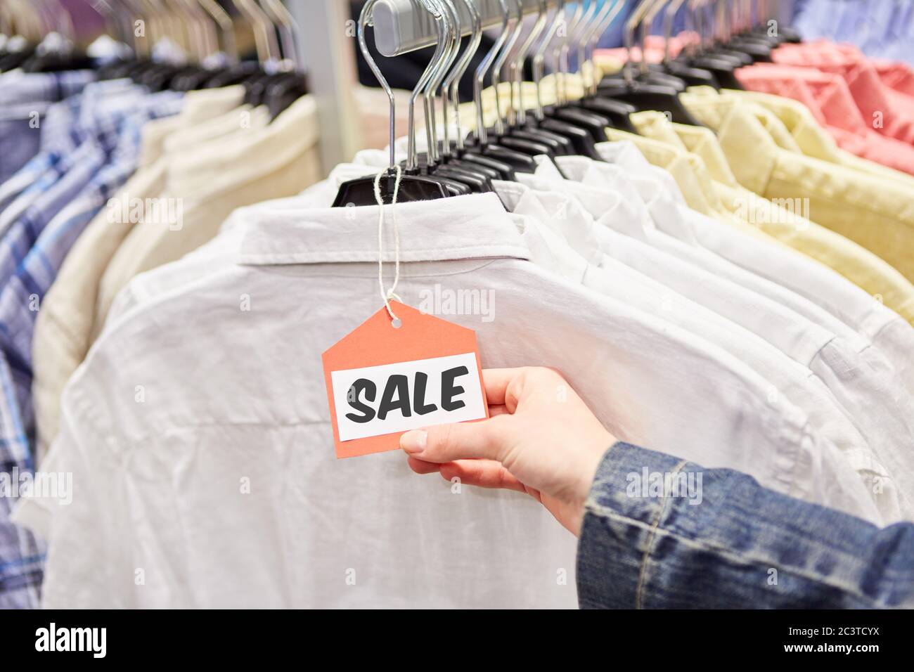 Hand on sale price tag on clothing in retail Stock Photo - Alamy