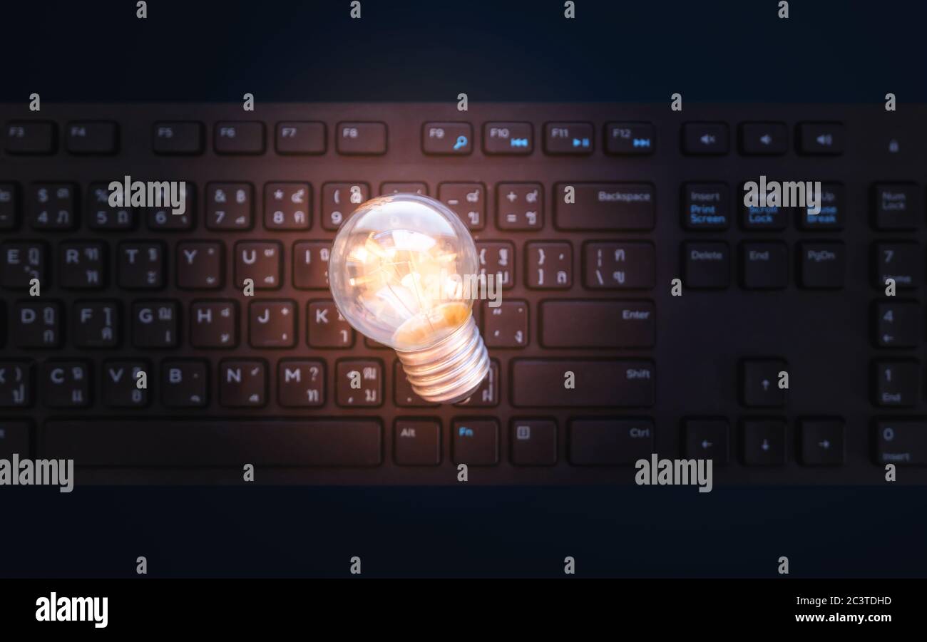 Glowing light bulb on computer keyboard Stock Photo - Alamy