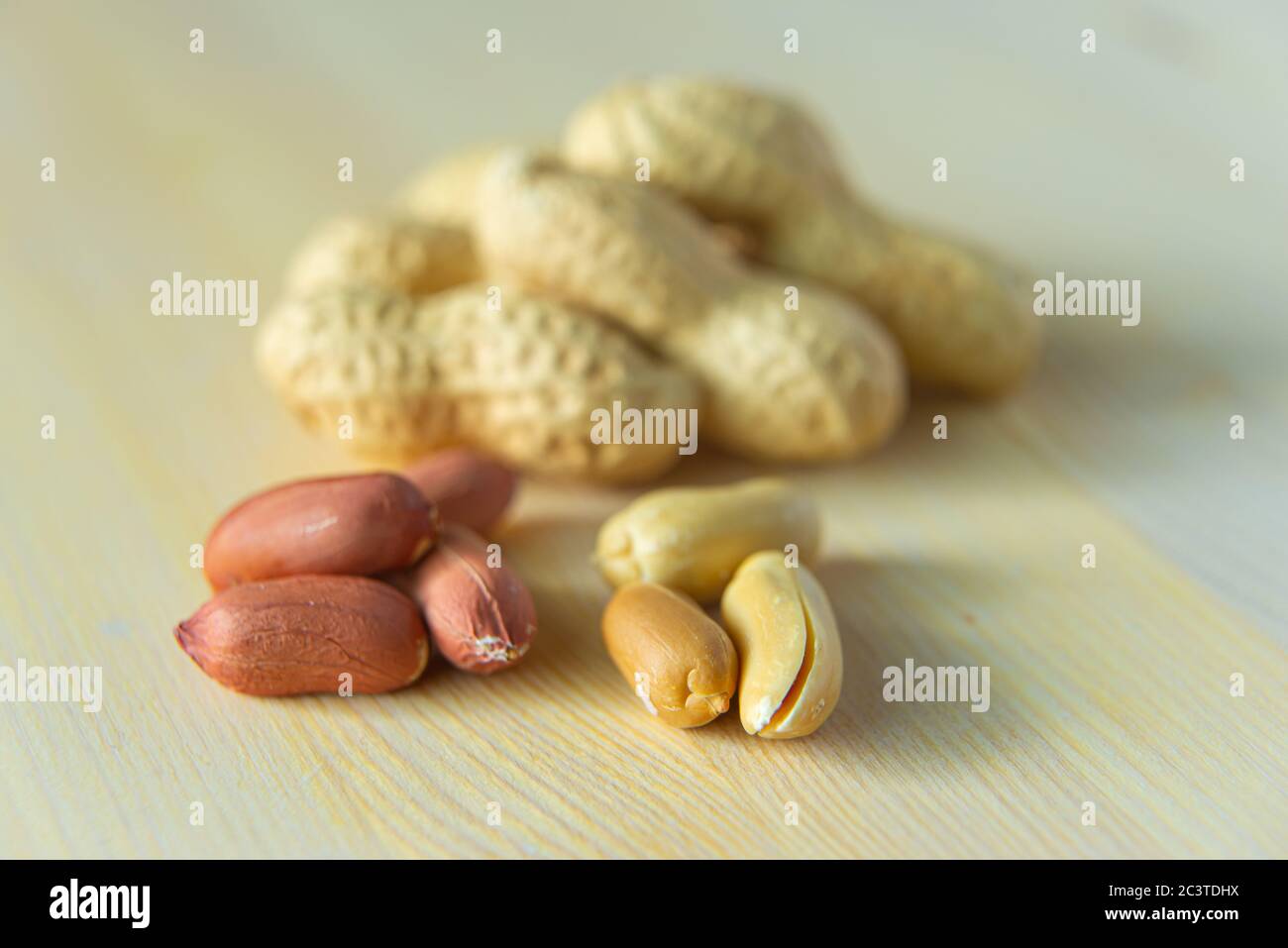Peanuts with and without shell, on wooden surface Peanuts with and ...