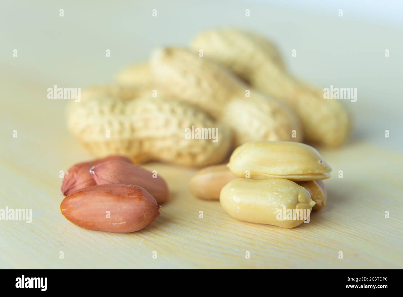 Peanuts with and without shell, on wooden surface Peanuts with and ...