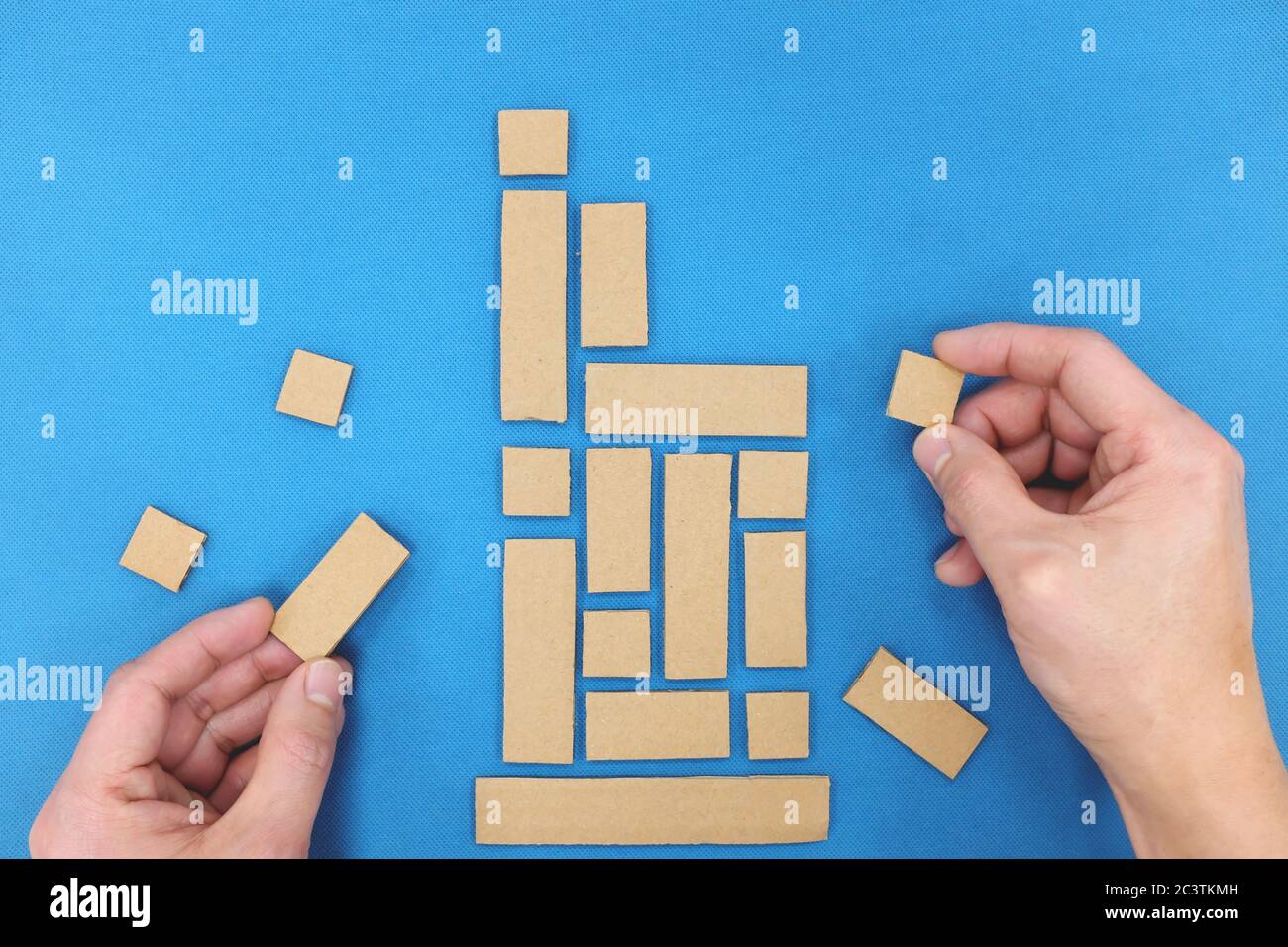 Nation rebuilding concept. Hands fixing fallen building blocks. Blue ...