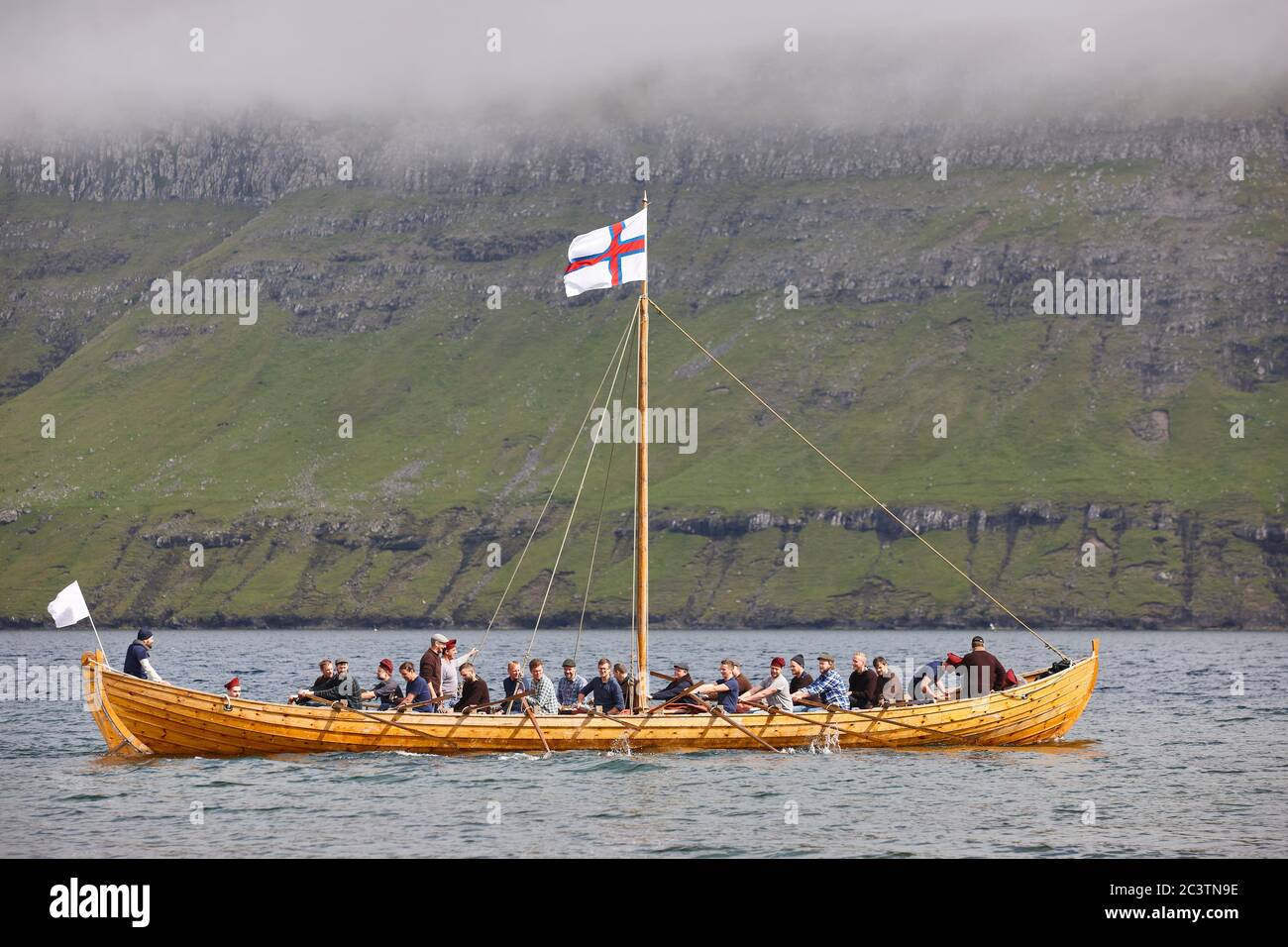 Traditional faroese wooden ship with paddlers on the fjord. Faroe Stock ...
