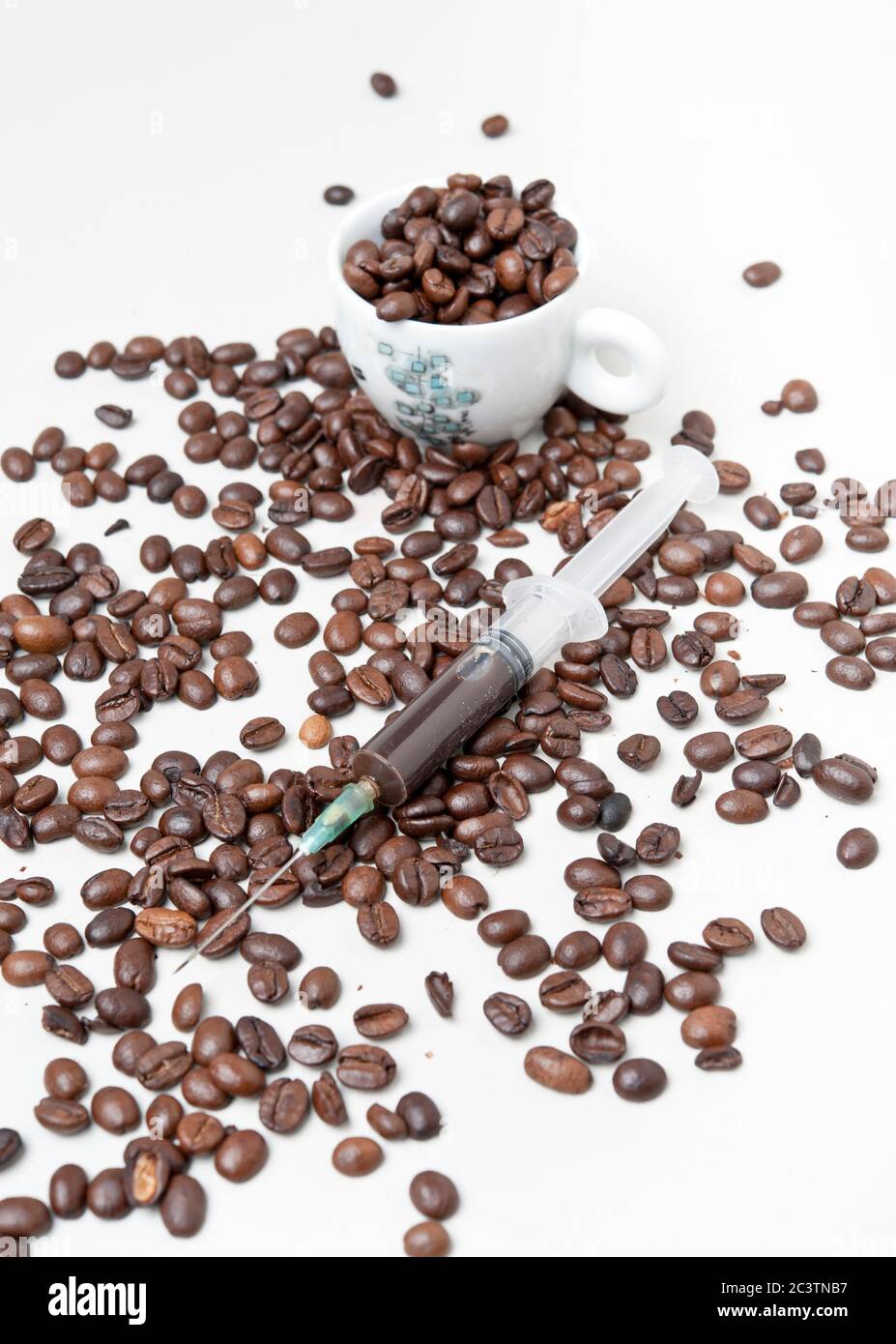 caffein addiction concept . Coffee beans and a syringe of caffeine ...