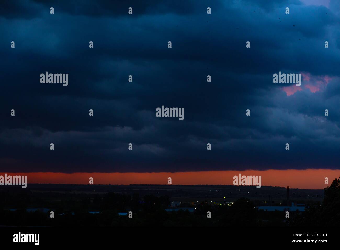 Black thunderclouds at sunset. Bright orange sunset and dark clouds ...