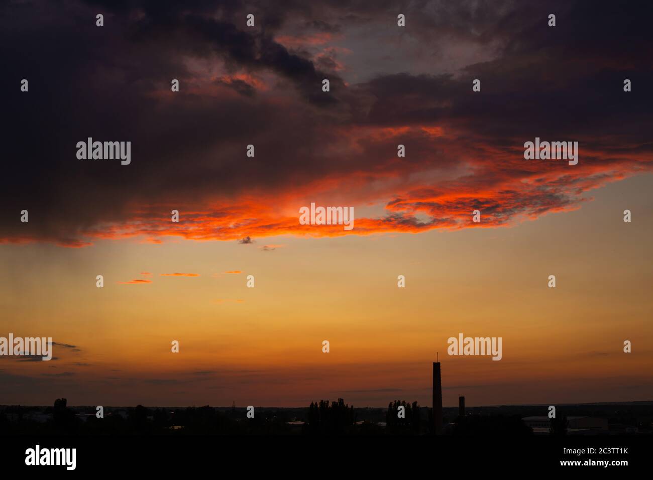 Black thunderclouds at sunset. Bright orange sunset and dark clouds ...
