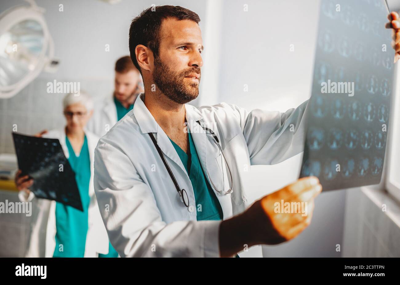 Medical team doctors checking on X-ray results in hospital Stock Photo ...