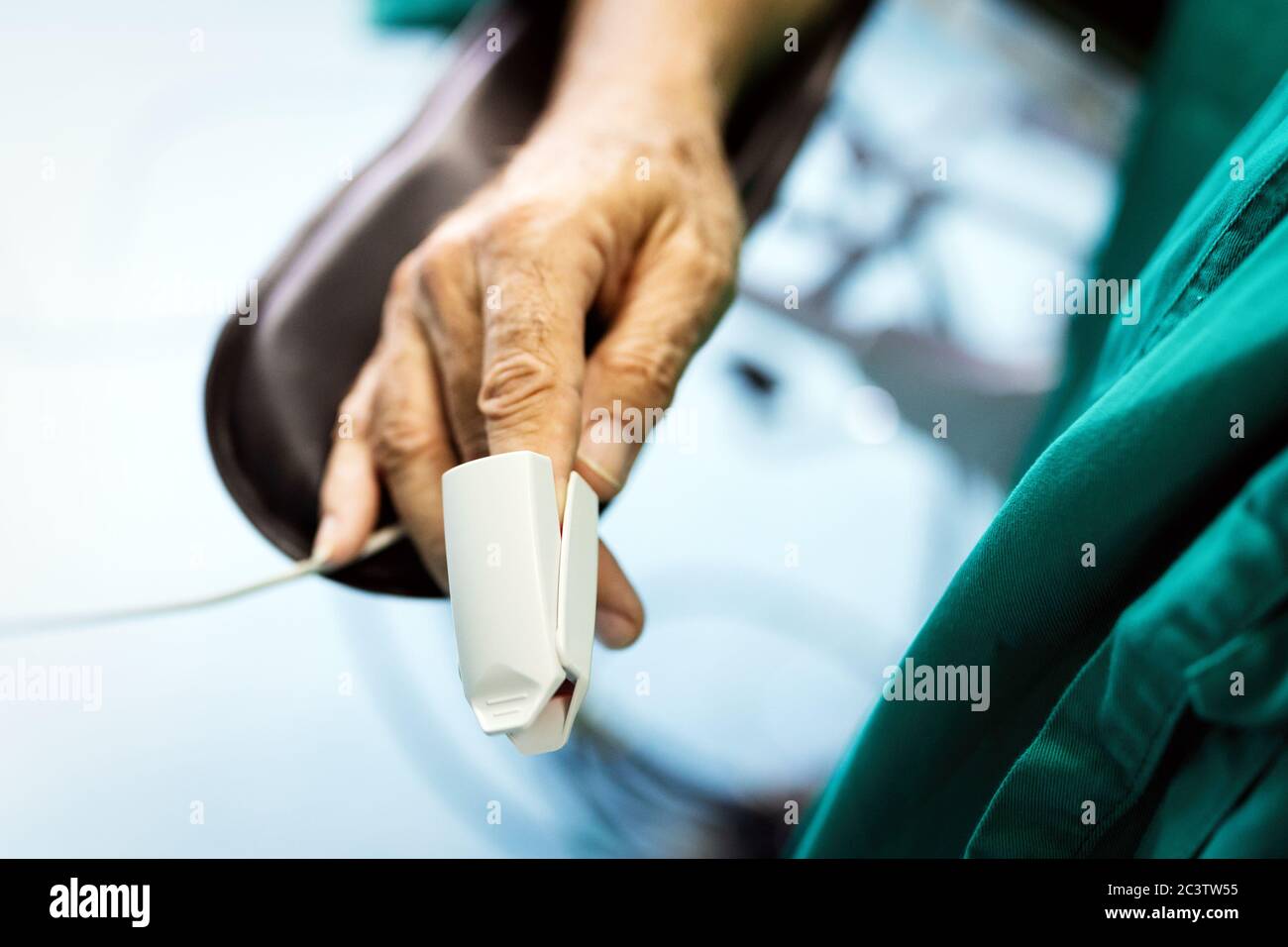 Patient with pulse oximeter on finger for monitoring during surgery ...