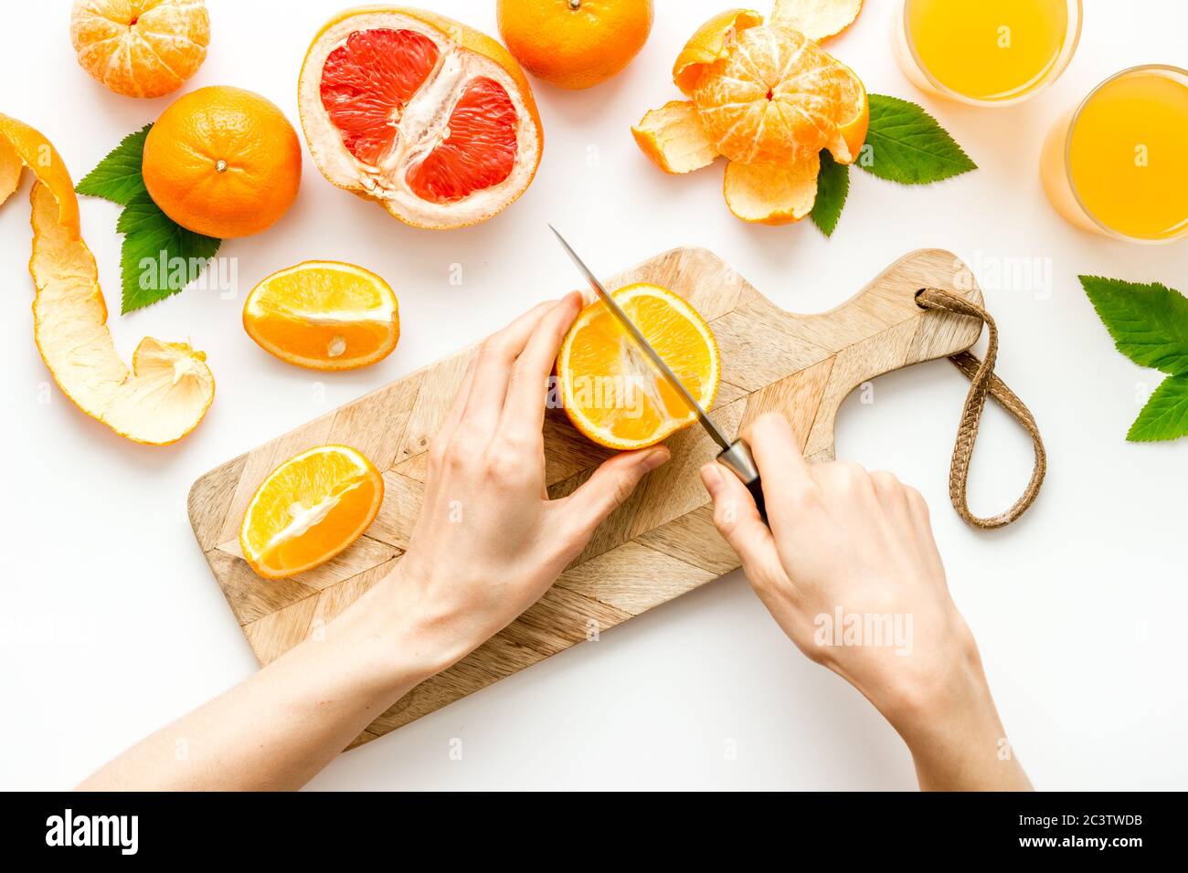 Hands cutting citrus fruit on board top view Stock Photo - Alamy