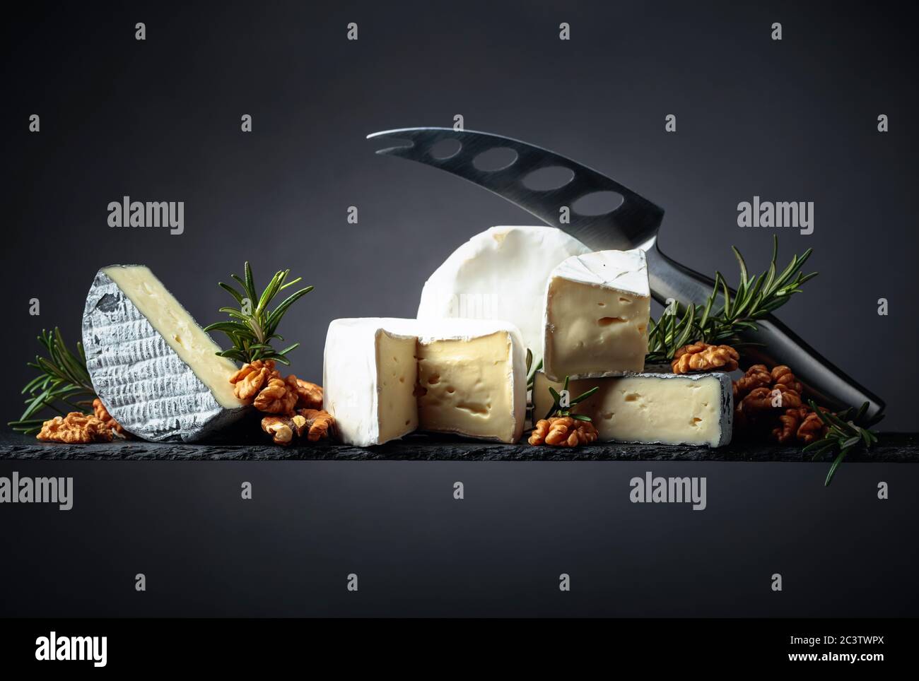 Various soft cheeses with walnuts and rosemary. Copy space Stock Photo ...
