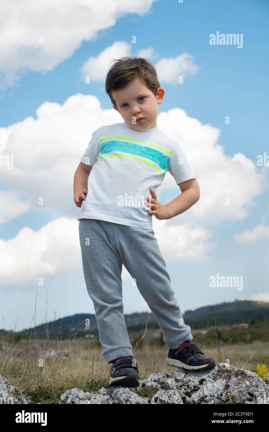 Boy posing on the rock Stock Photo - Alamy