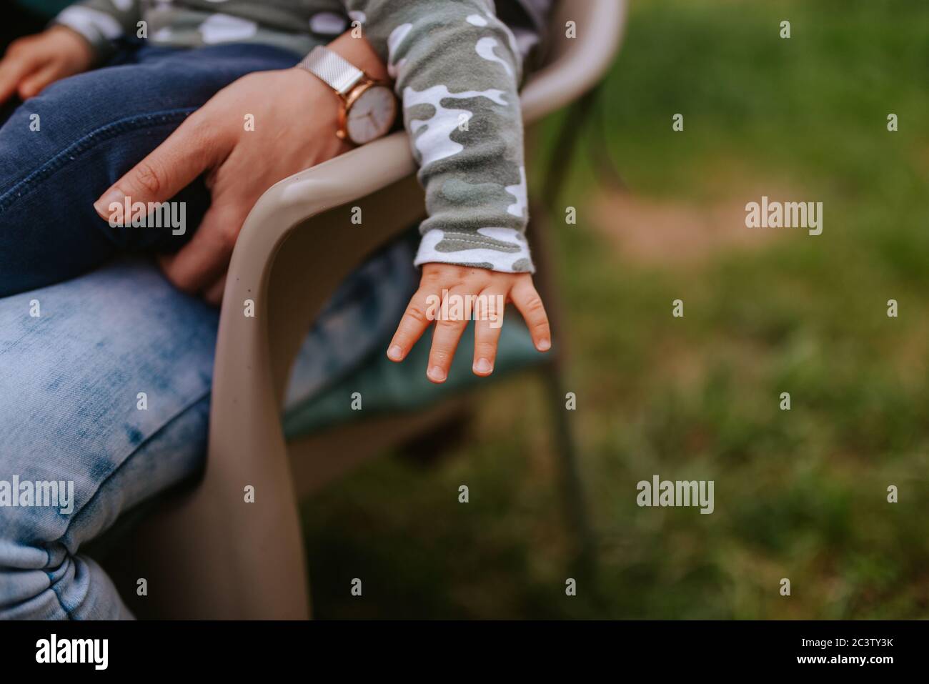 Close up of a a child's hand while sitting at mom's lap Stock Photo - Alamy