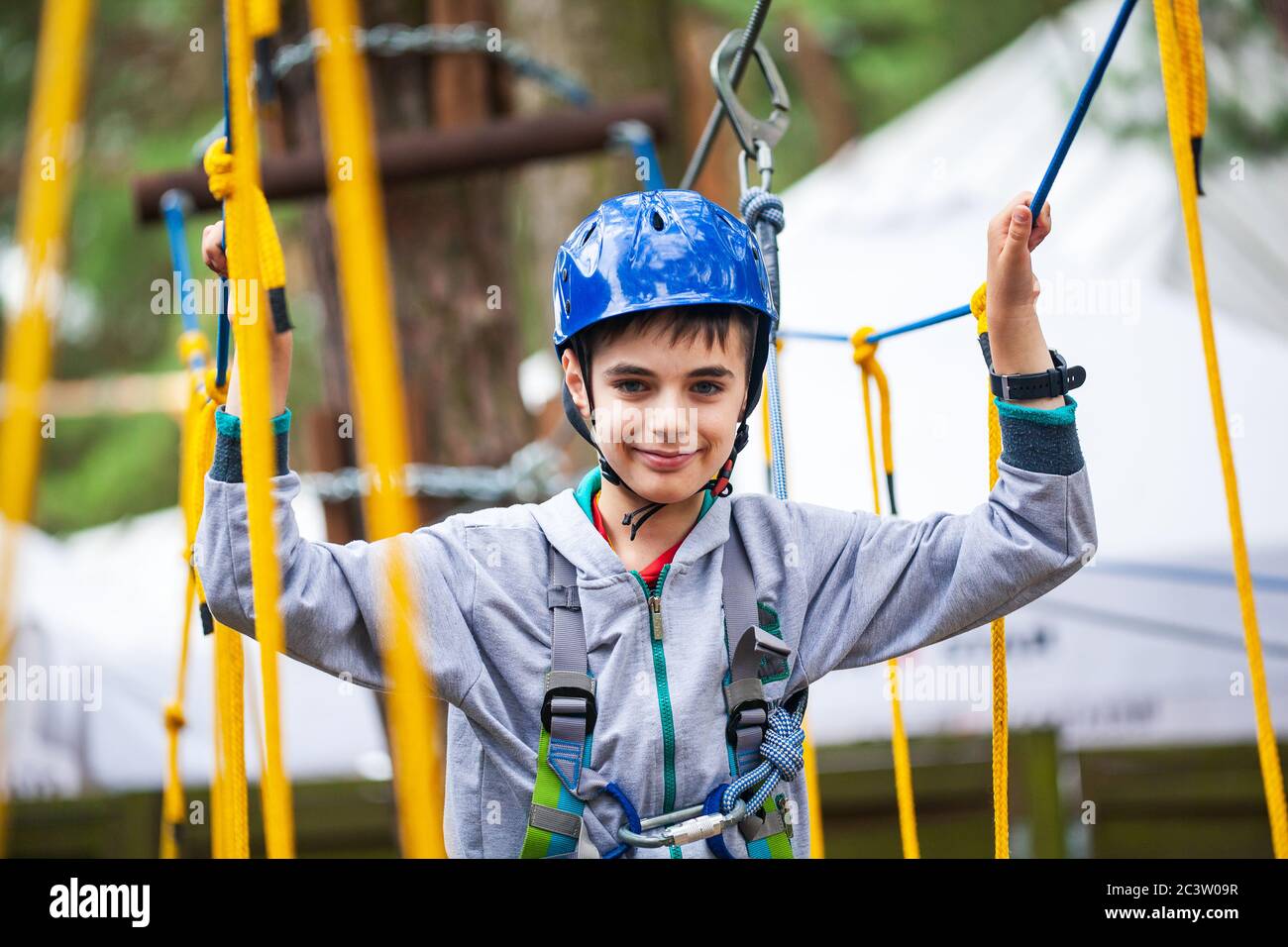 Young boy climbing pass obstacles in rope. Child in forest adventure ...