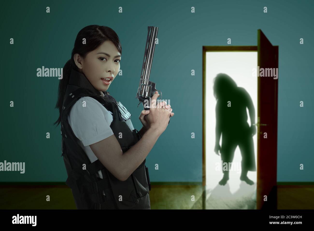 Asian woman in police vest with a gun on her hand ready to attack ...