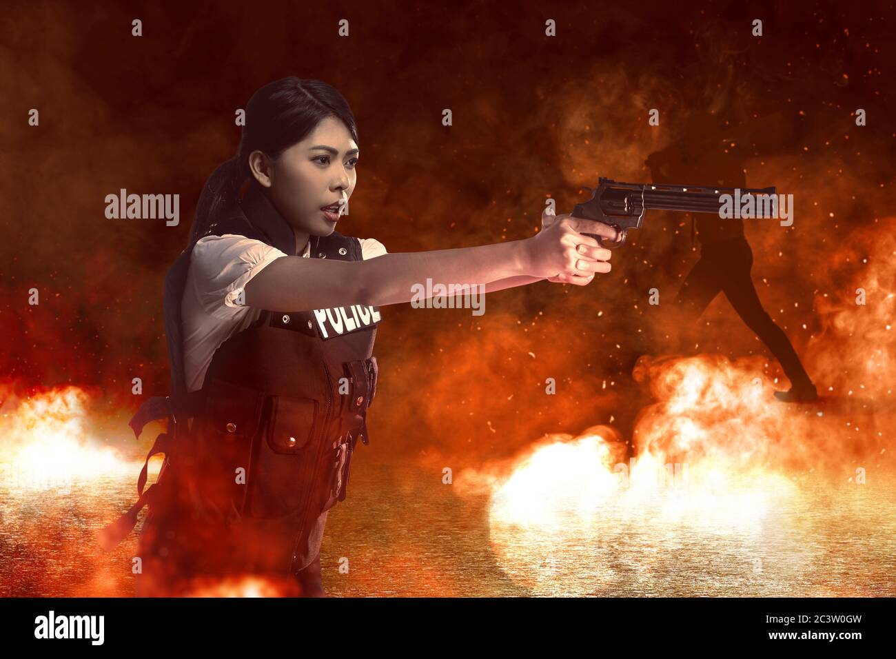 Asian woman in police vest pointing a gun controlling the situation of ...