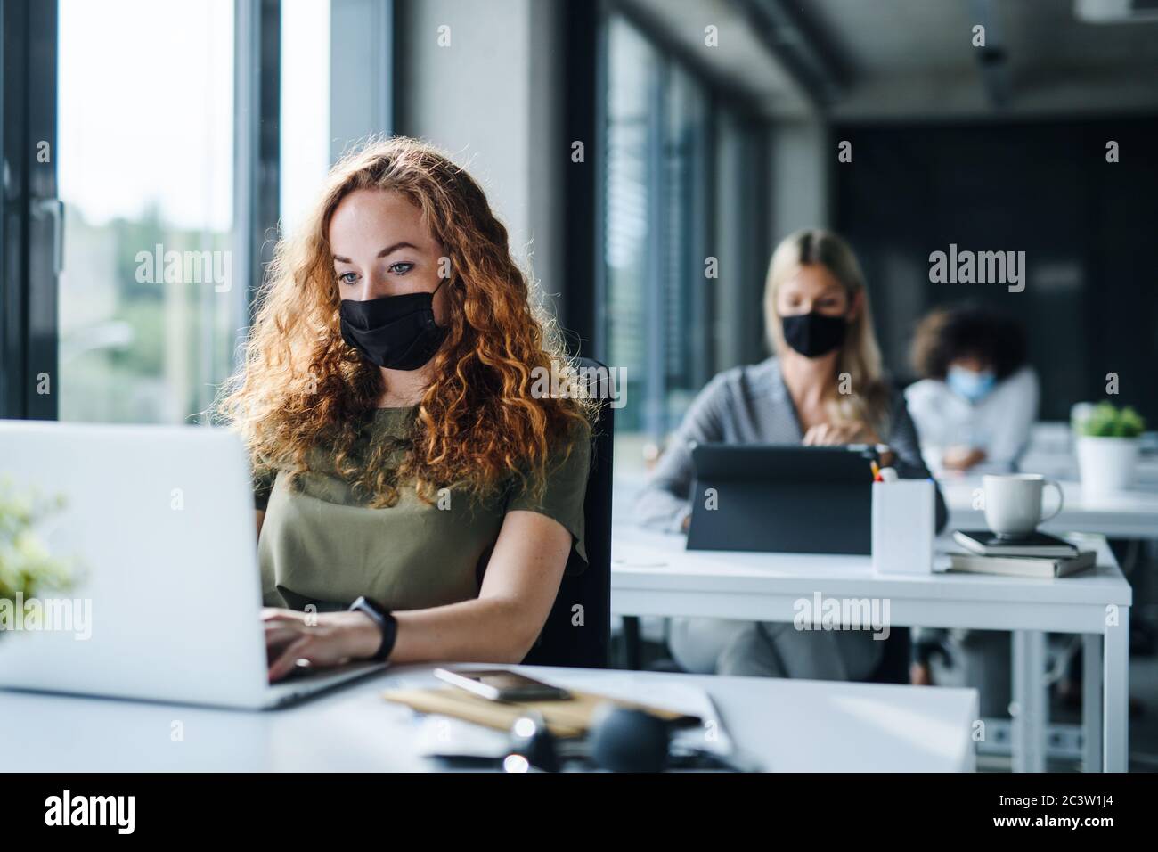 Young people with face masks back at work or school in office after ...