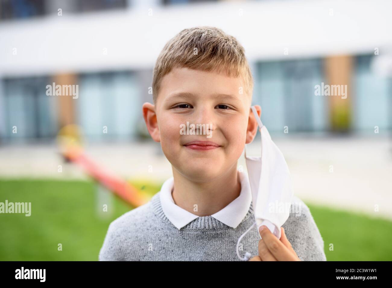 Portrait of happy boy with face mask going back to school after covid ...