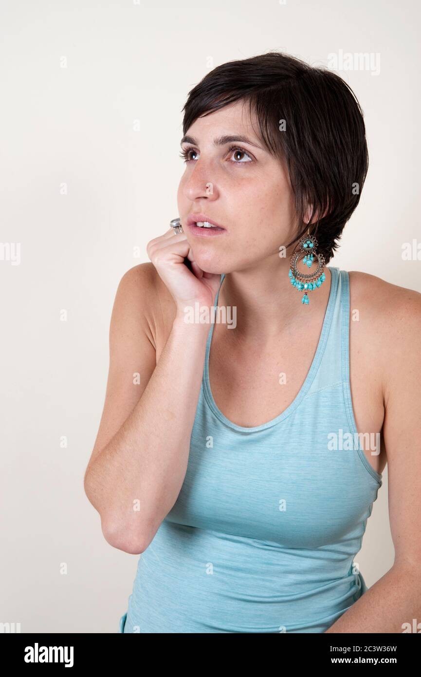 Studio shot of a fearful female model in her 20s on white background ...