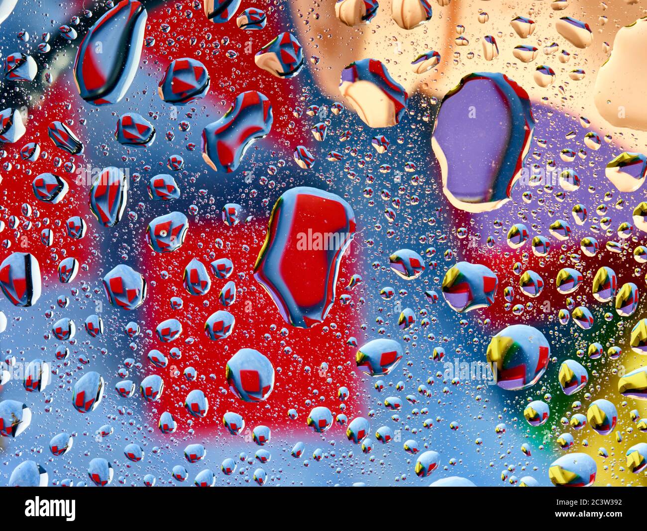 Colourful water drops, droplets, on a hard surface showing abstraction ...