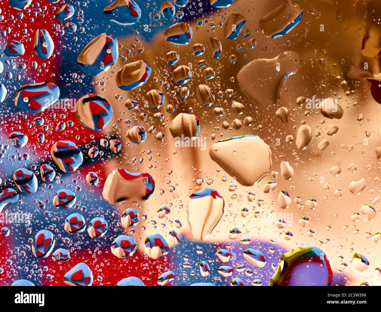 Colourful water drops, droplets, on a hard surface showing abstraction ...