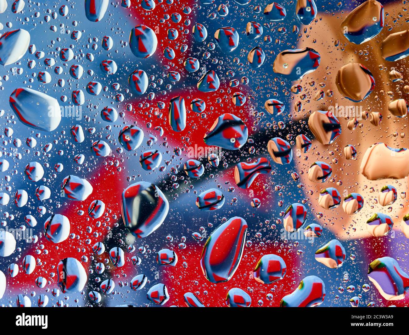 Colourful water drops, droplets, on a hard surface showing abstraction ...