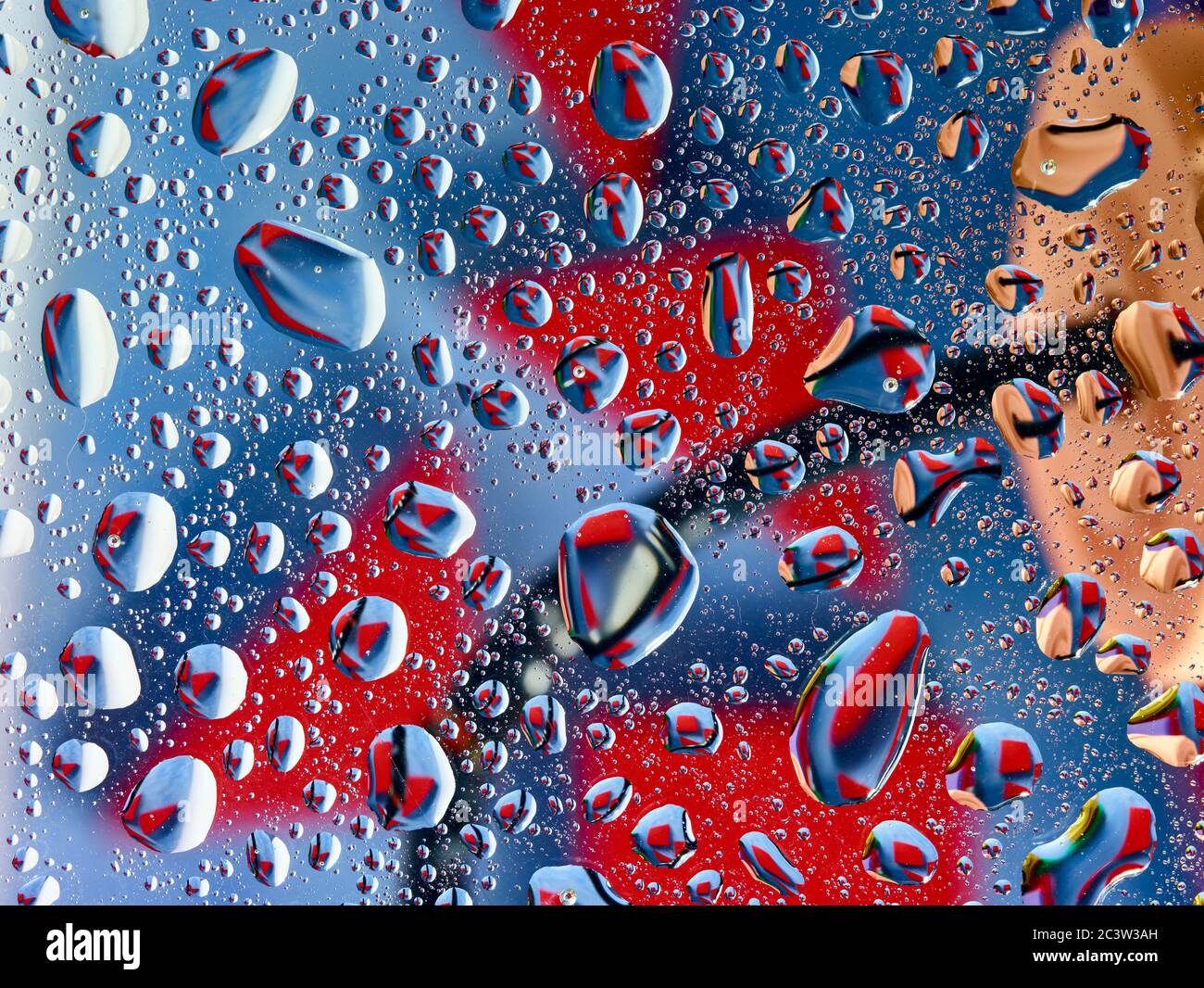 Colourful water drops, droplets, on a hard surface showing abstraction ...