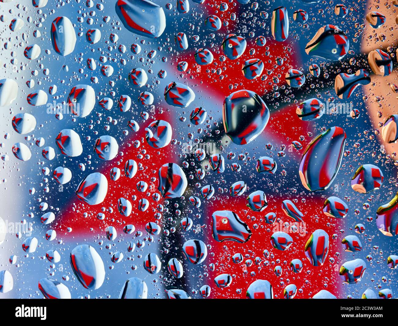 Colourful water drops, droplets, on a hard surface showing abstraction ...