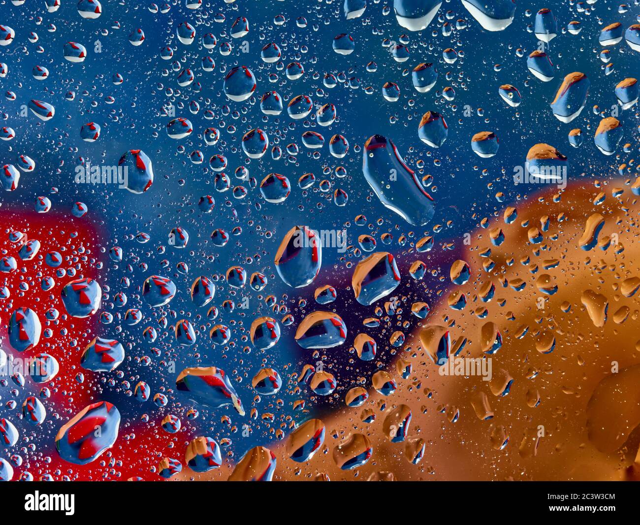 Colourful water drops, droplets, on a hard surface showing abstraction ...