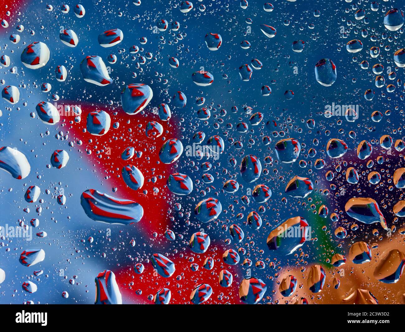 Colourful water drops, droplets, on a hard surface showing abstraction ...