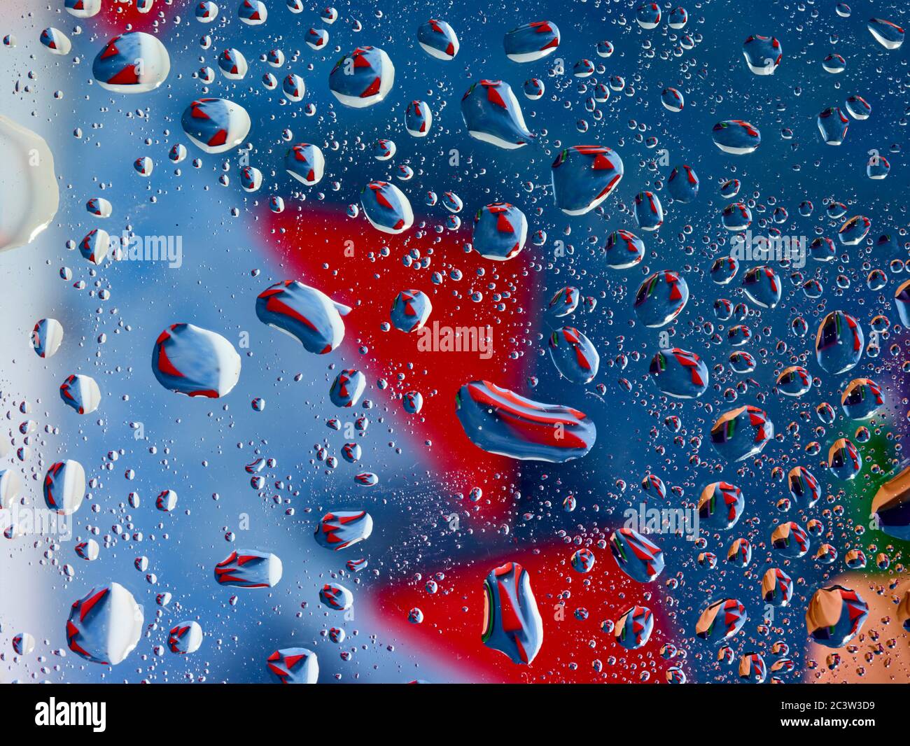 Colourful water drops, droplets, on a hard surface showing abstraction ...