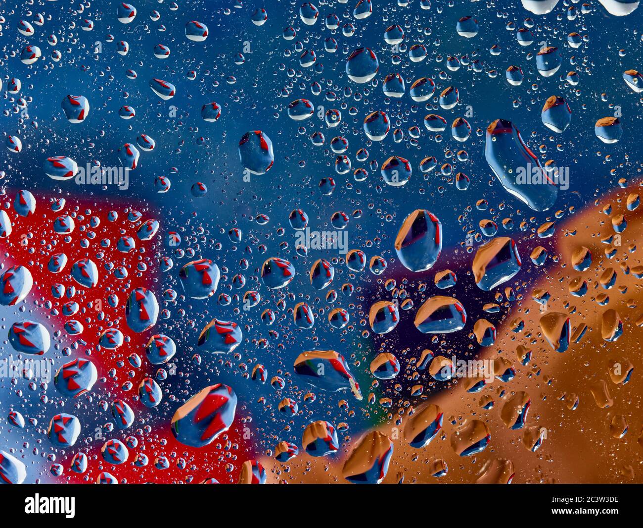 Colourful water drops, droplets, on a hard surface showing abstraction ...