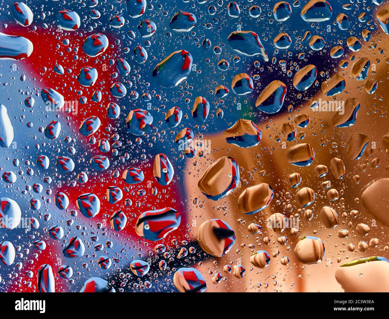 Colourful water drops, droplets, on a hard surface showing abstraction ...