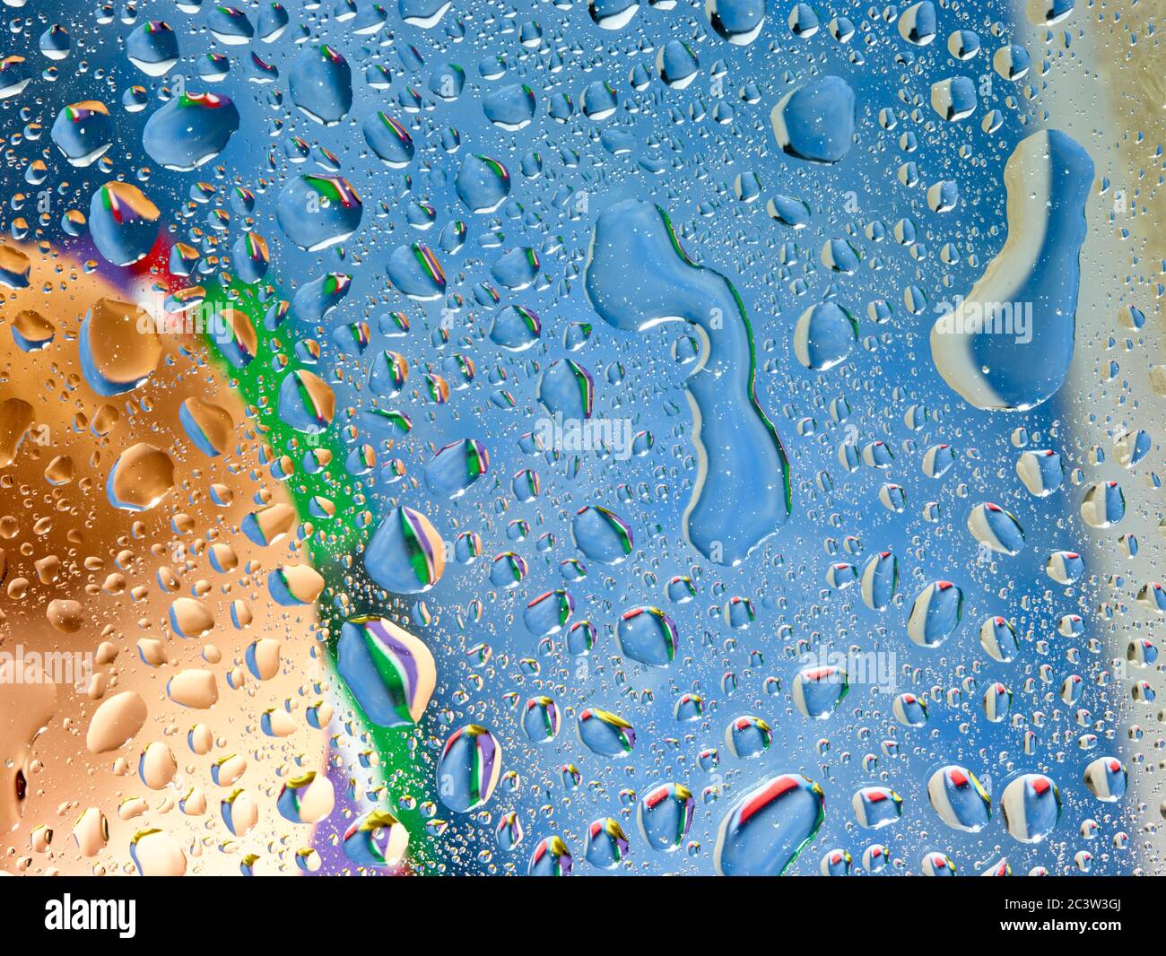 Colourful water drops, droplets, on a hard surface showing abstraction ...