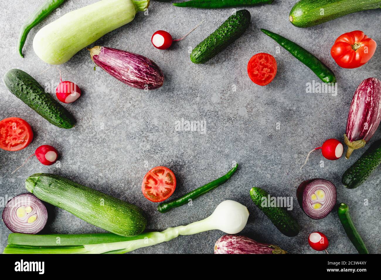Colorful summer pattern with different fresh vegetables on a grey ...