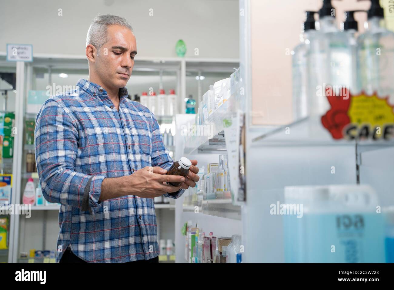 Men reading label of medicine bottle Stock Photo - Alamy