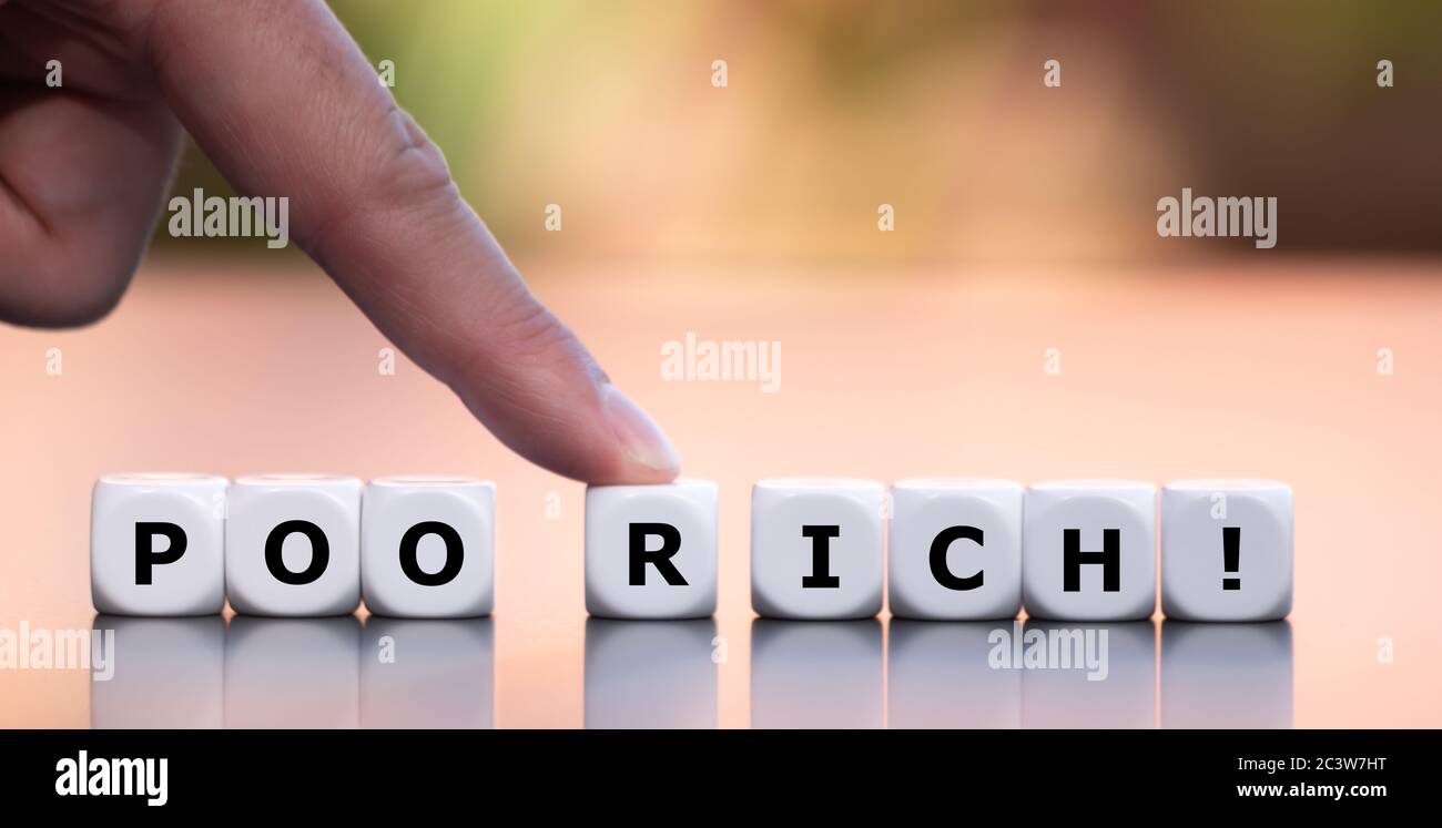 Hand moves dice and changes the word "poor" to "rich Stock Photo - Alamy
