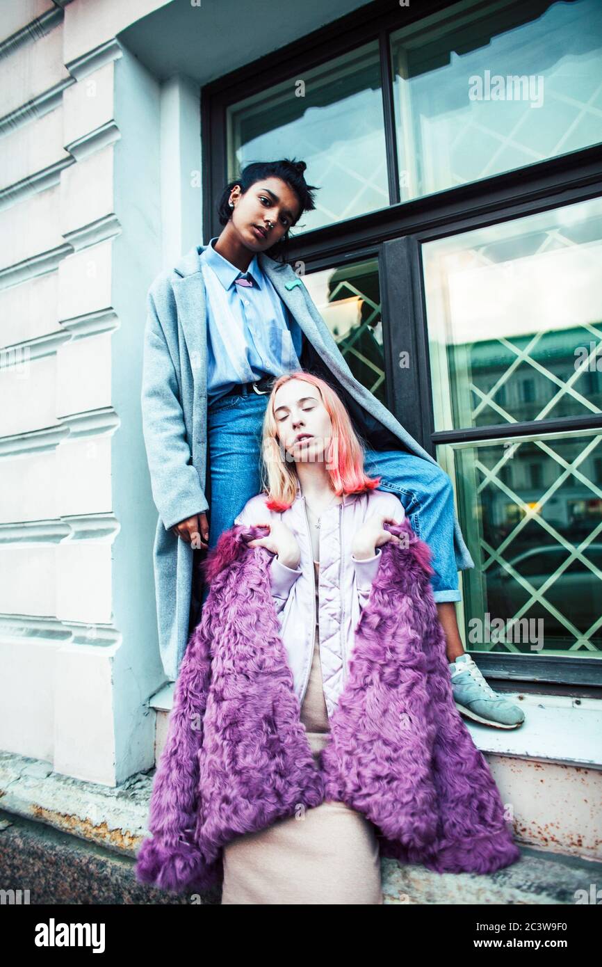 Two teenage girls infront of university building smiling, having fun ...