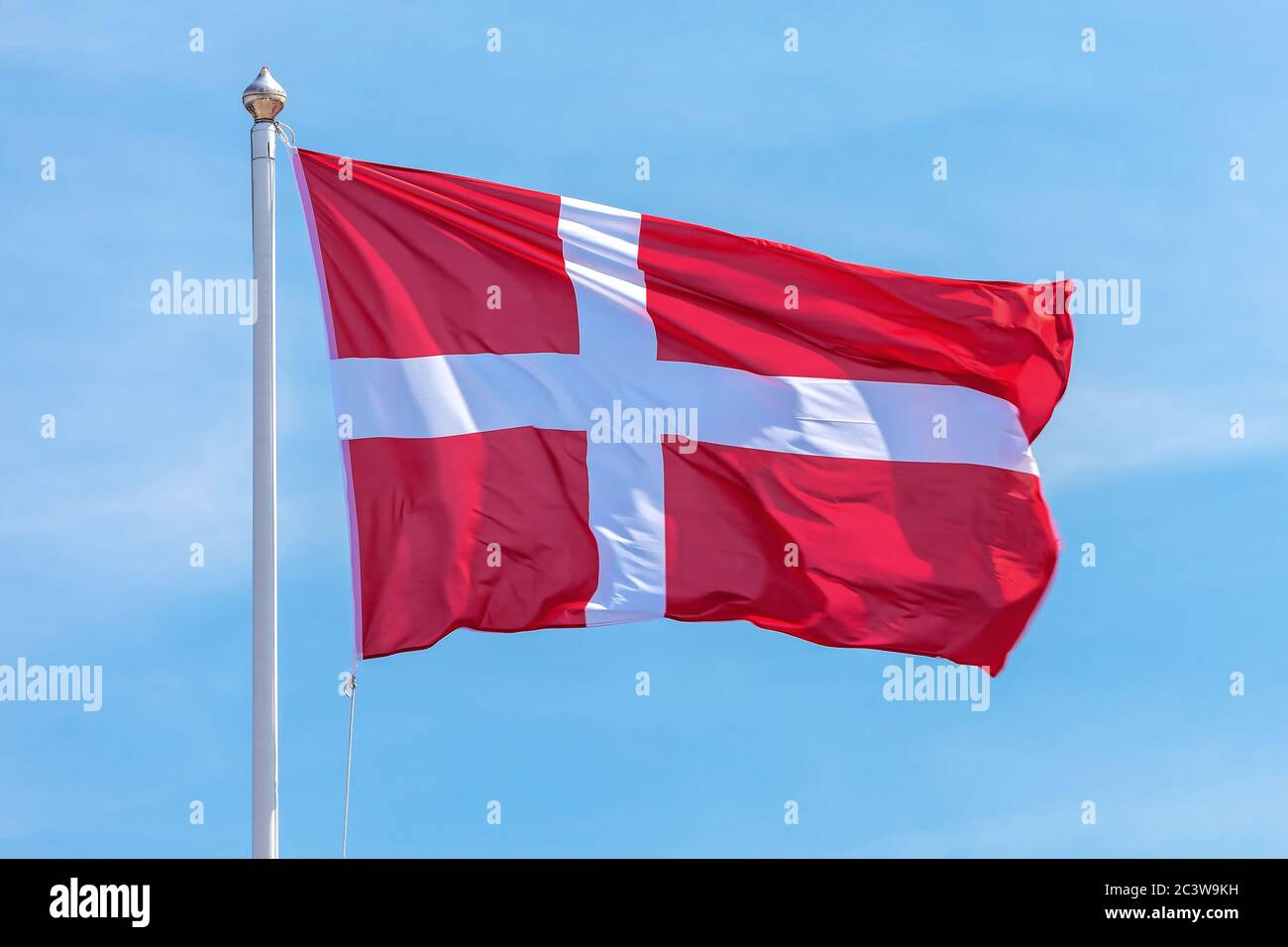 The official flag of Denmark in front of a blue sky Stock Photo - Alamy