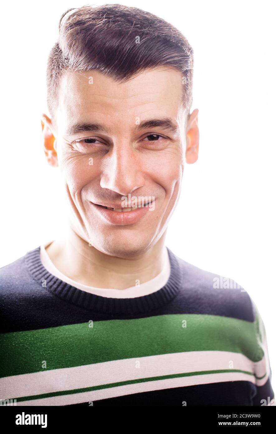 Portrait of a smart serious young man standing against white background ...